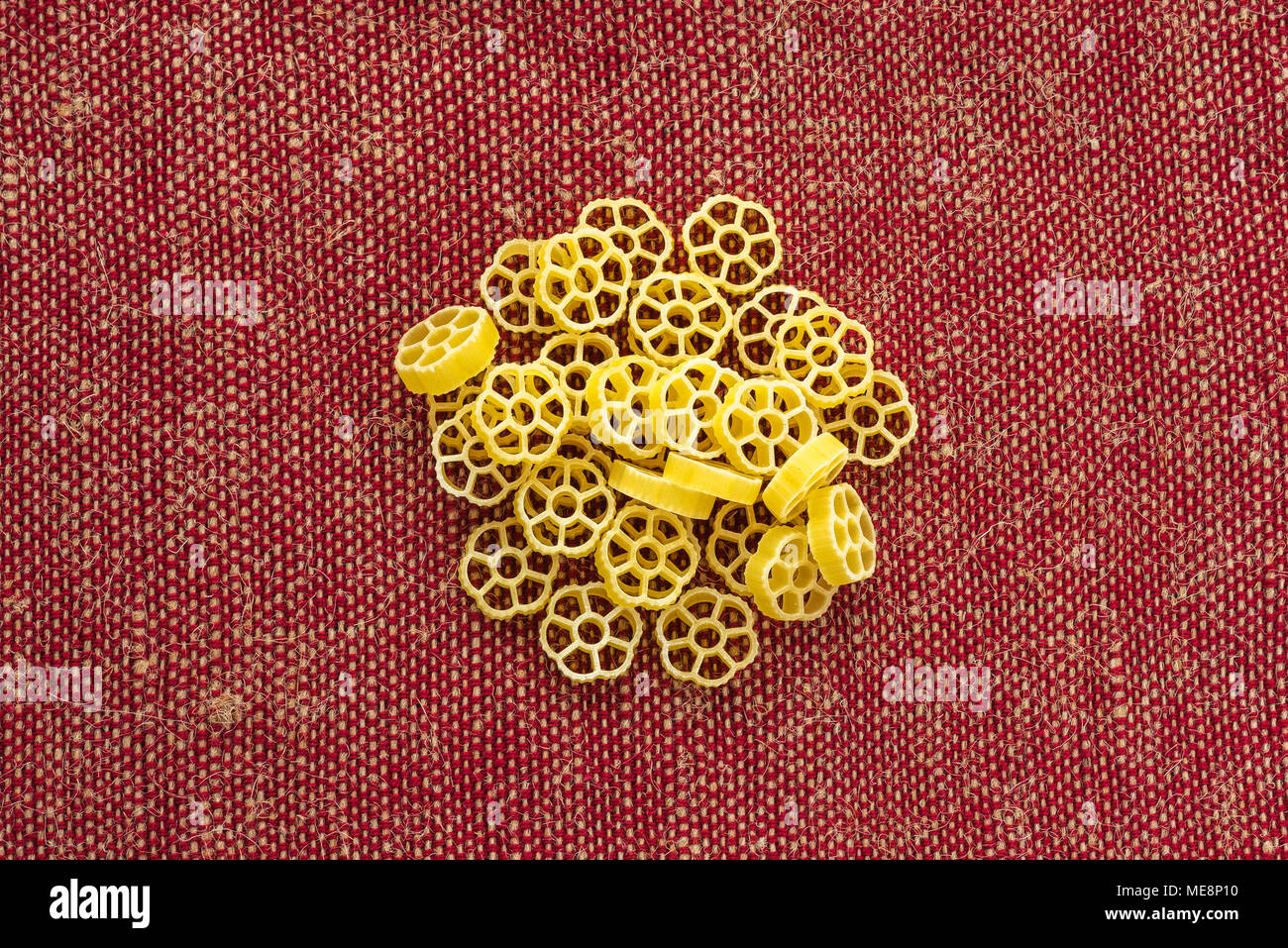 Raw ruote background with pasta on rustic red brown background. A view ...