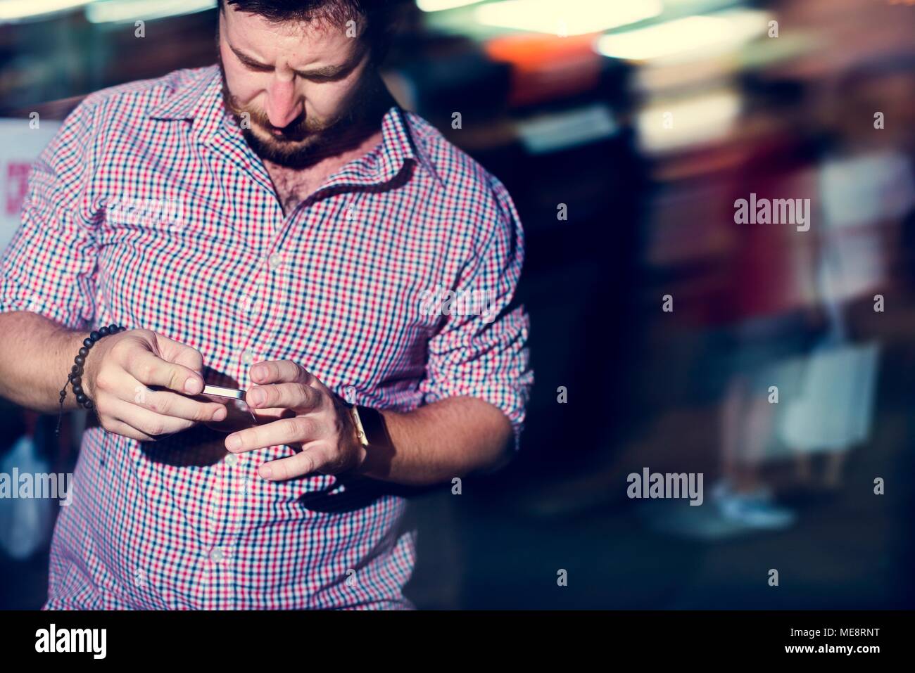Closeup of a man using mobile phone in the dark with long exposure ...