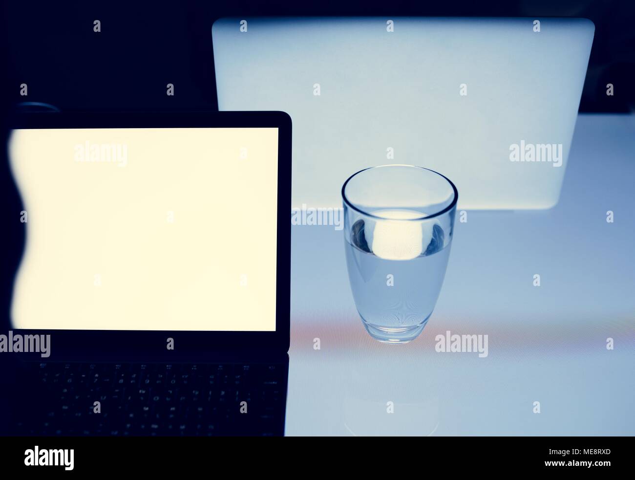 Office desk with a laptop and a glass of water Stock Photo - Alamy