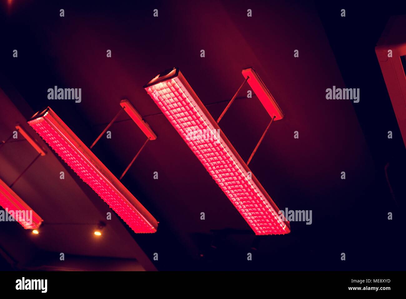 Red fluorescent lamp hanging from the ceiling Stock Photo - Alamy