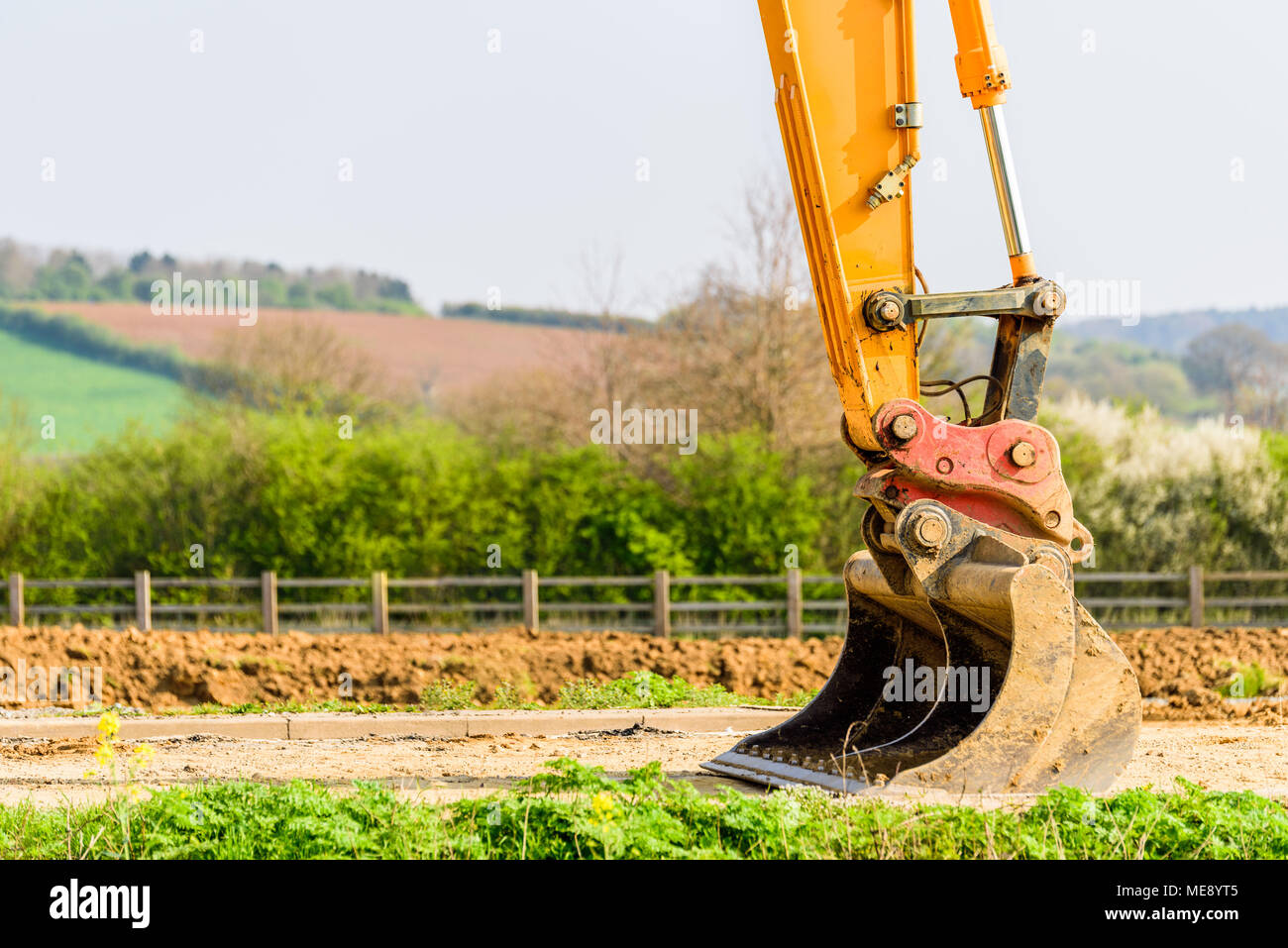 A large yellow construction excavator bucket over British countryside ...