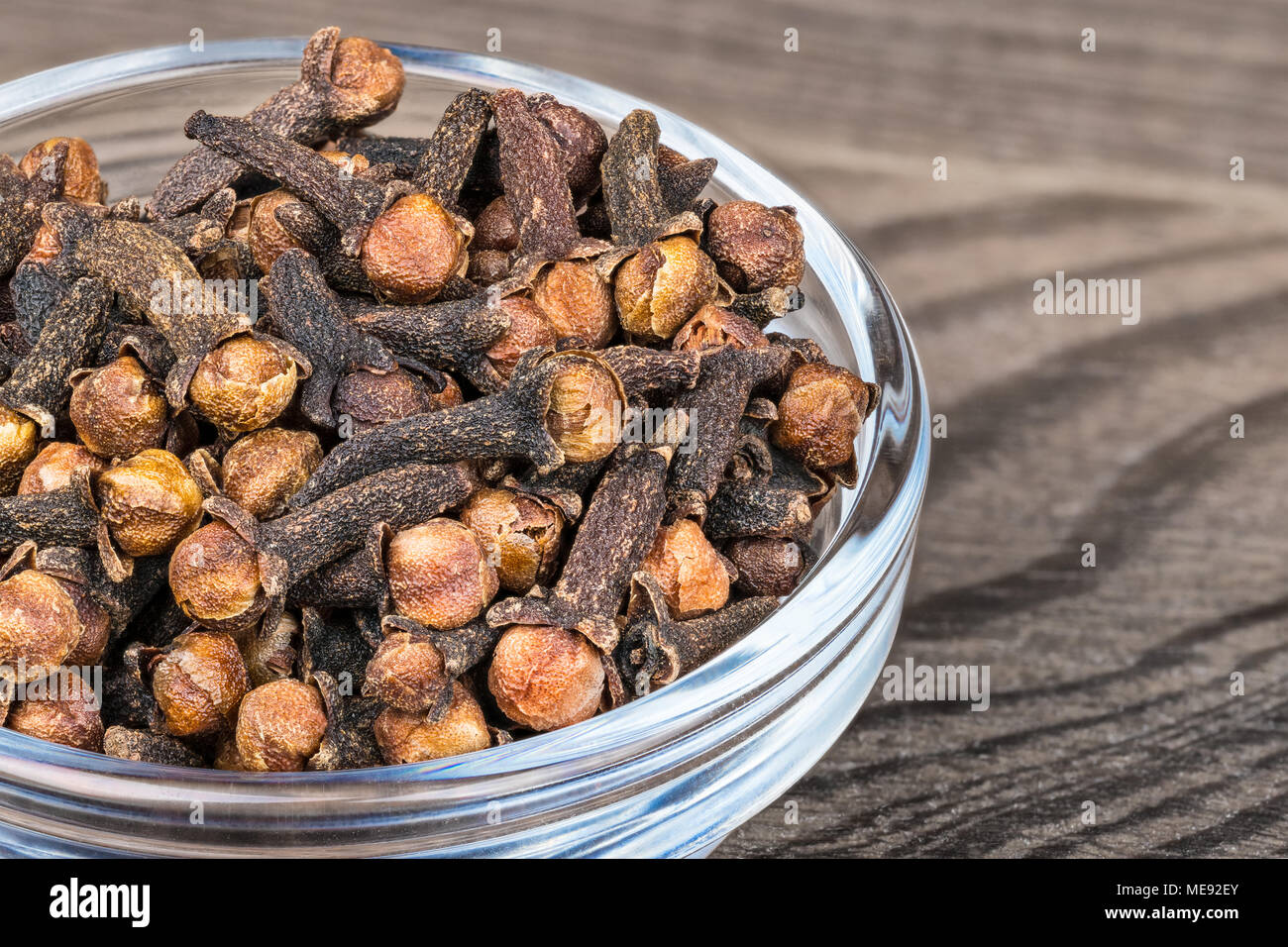 Close-up of spicy dried cloves. Syzygium aromaticum. Decorative glass ...