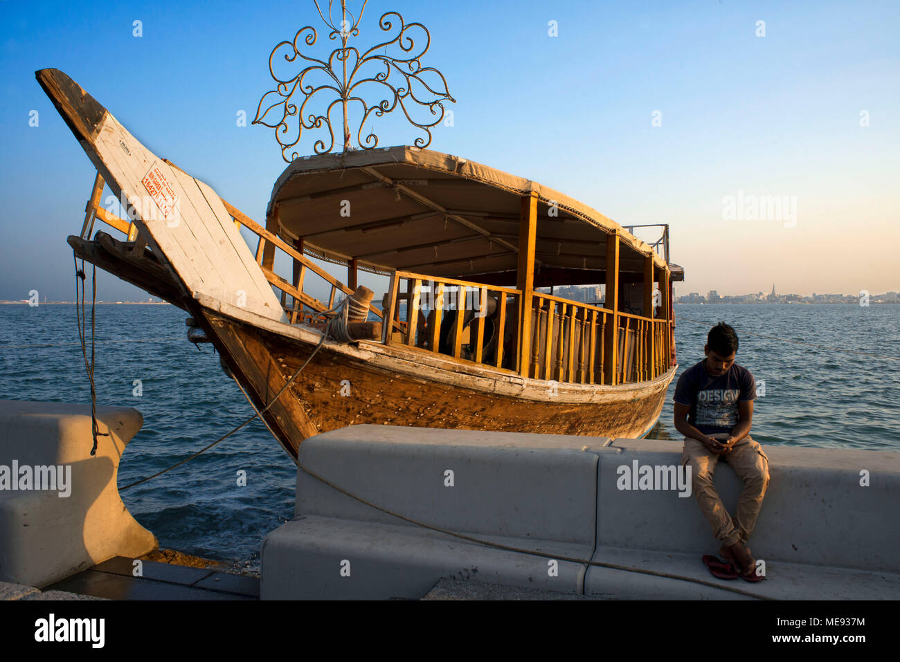 Dhow traditional sailing for tourists in Corniche promenade. Behind the ...