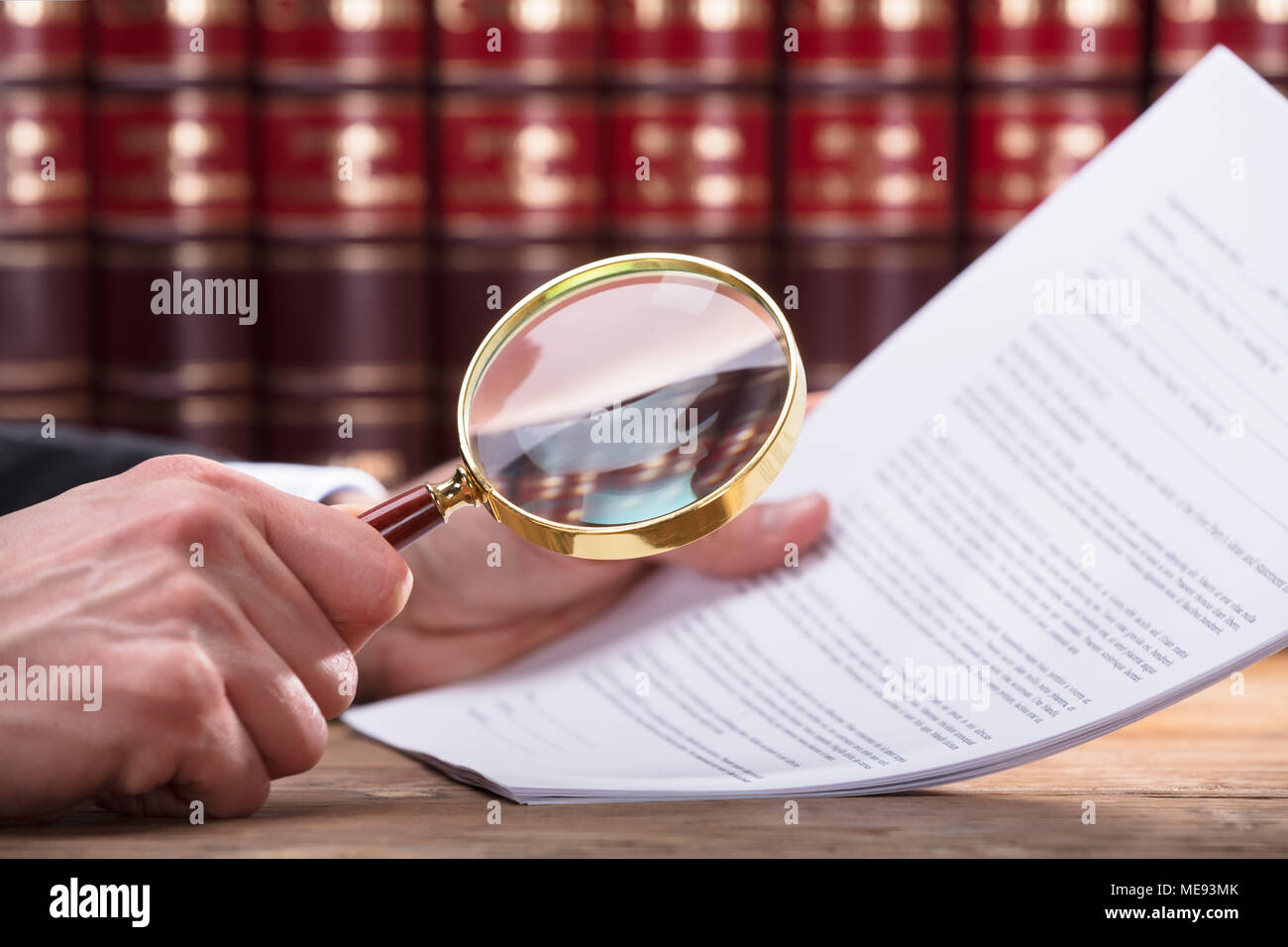Human Hand Examining Document Through Magnifying Glass Stock Photo - Alamy