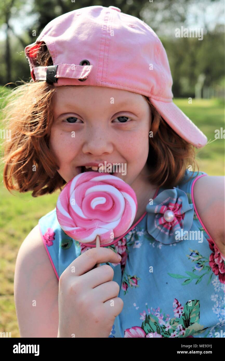 Girl licking a lollipop hi-res stock photography and images - Alamy