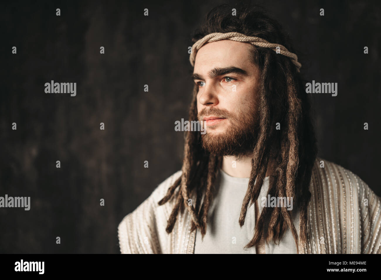 Portrait of man in the image of Jesus Christ, dark background ...