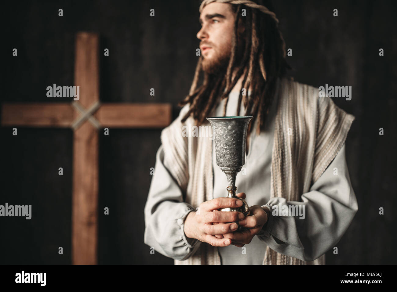 Man in the image of Jesus Christ holds a cup of wine, christian faith ...