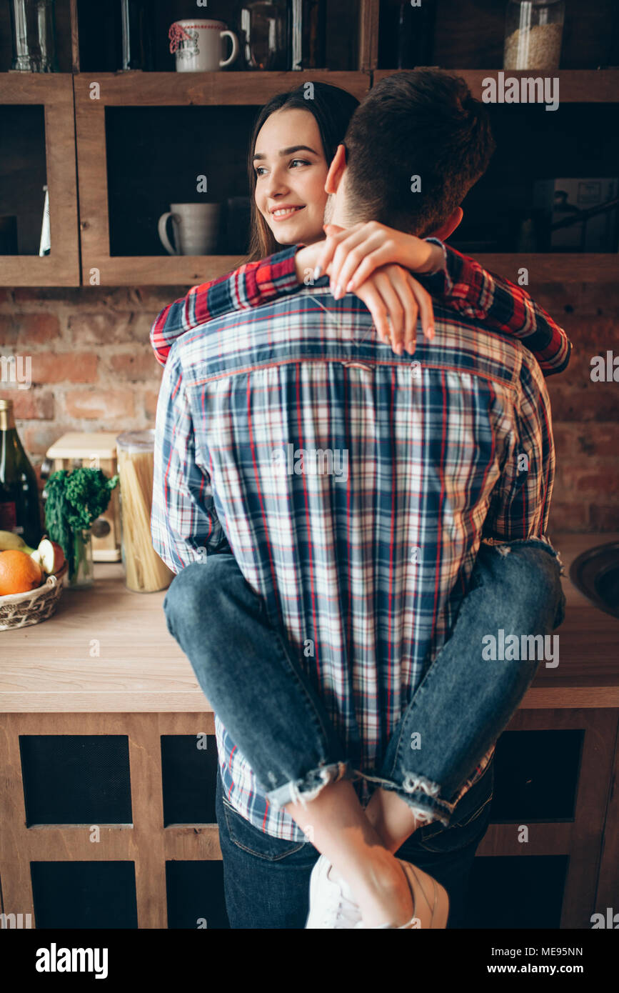 Young love couple hugs on the kitchen. Man and woman embrace, happy ...