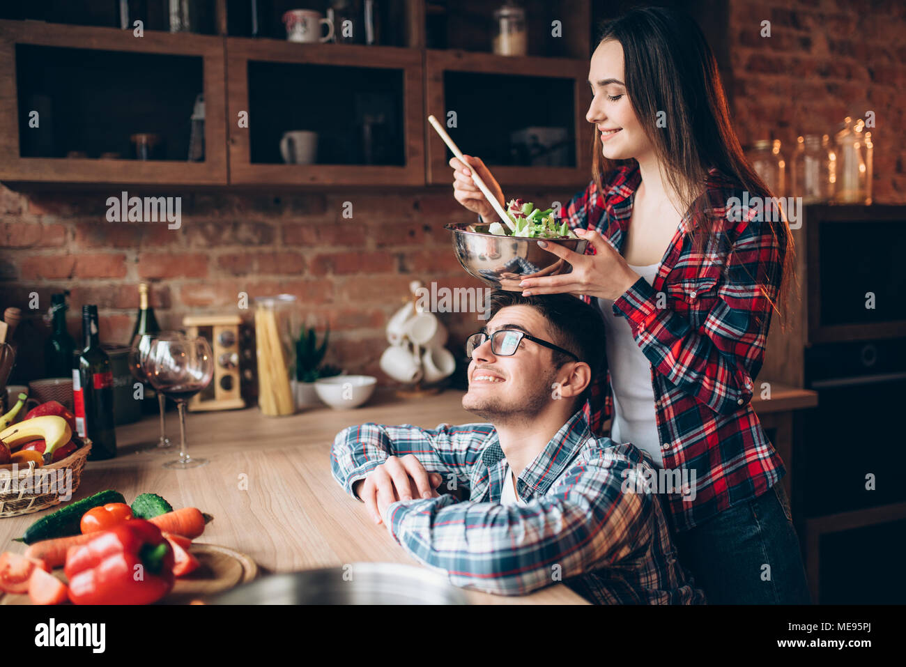 Happy couple cooking vegetable salad together, romantic dinner ...