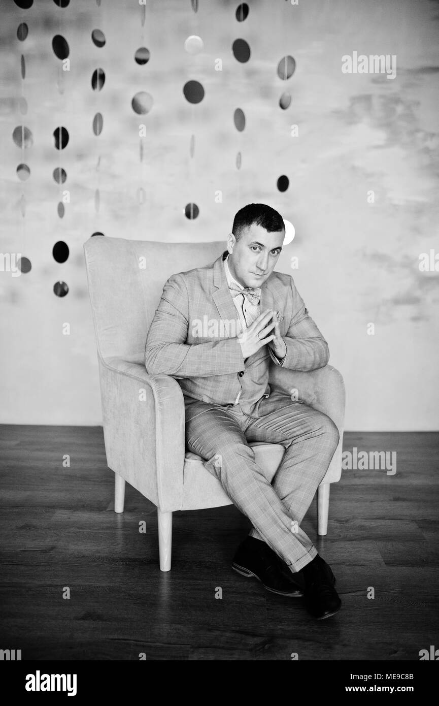 Studio portrait of man in suit near chair Stock Photo - Alamy