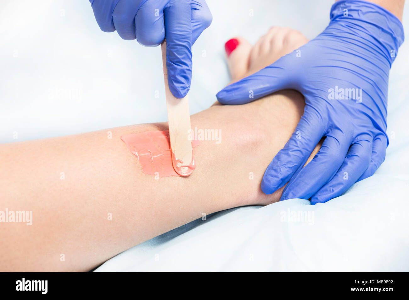 The process of classical wax depilation of female limbs in the beauty ...