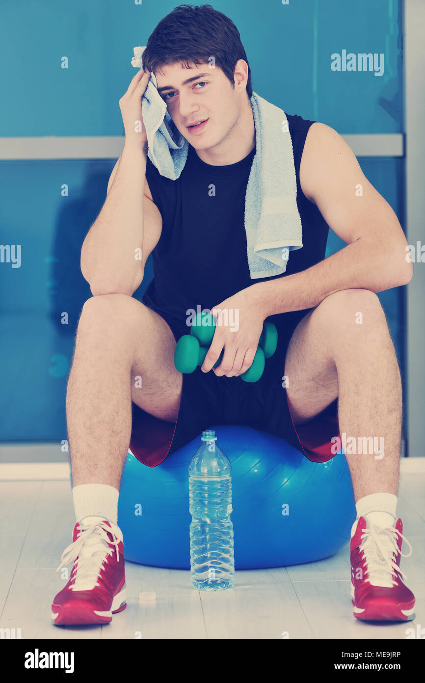 young man in fintess sport club exercise withweights and relaxing Stock ...