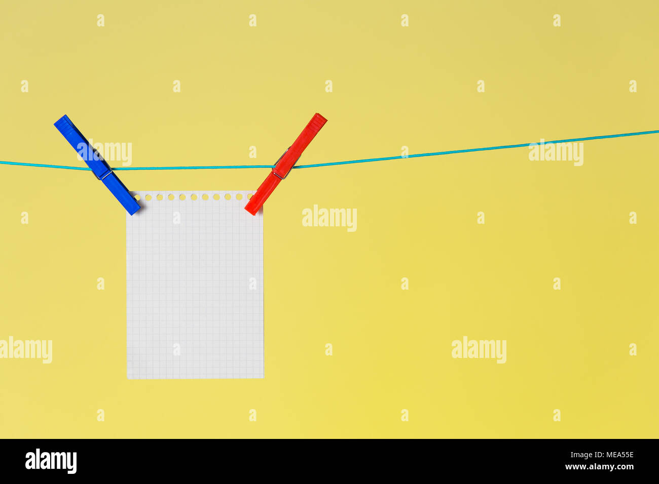 Blank note list pinned to rope on yellow background. Business notes ...