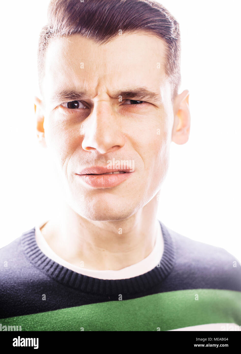 Portrait of a smart serious young man standing against white bac Stock ...