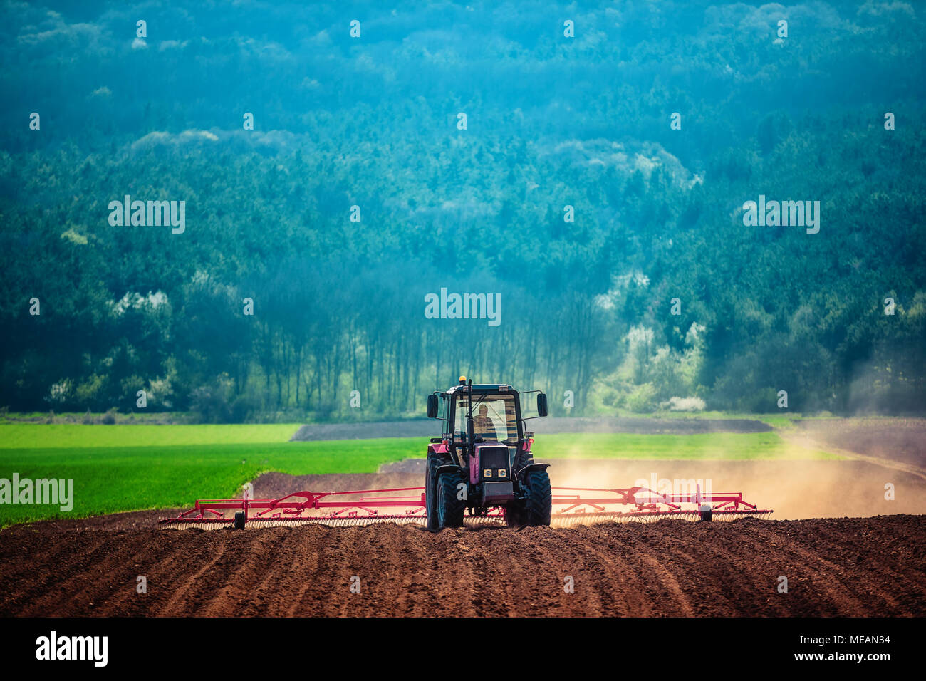 Farmer in tractor preparing land with seedbed cultivator Stock Photo ...