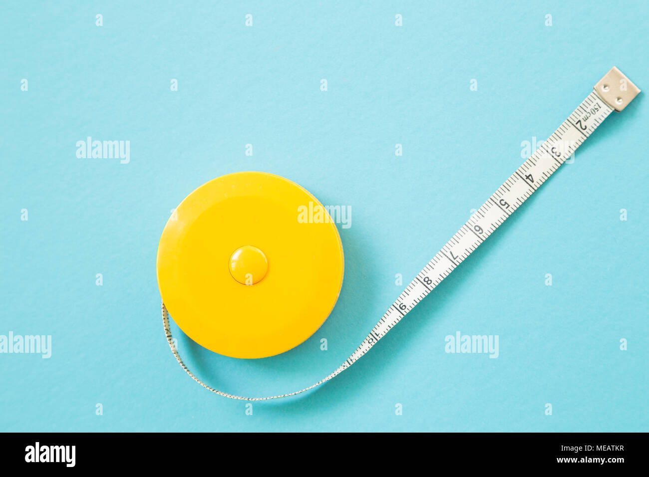 Tape measure on blue color background Stock Photo - Alamy