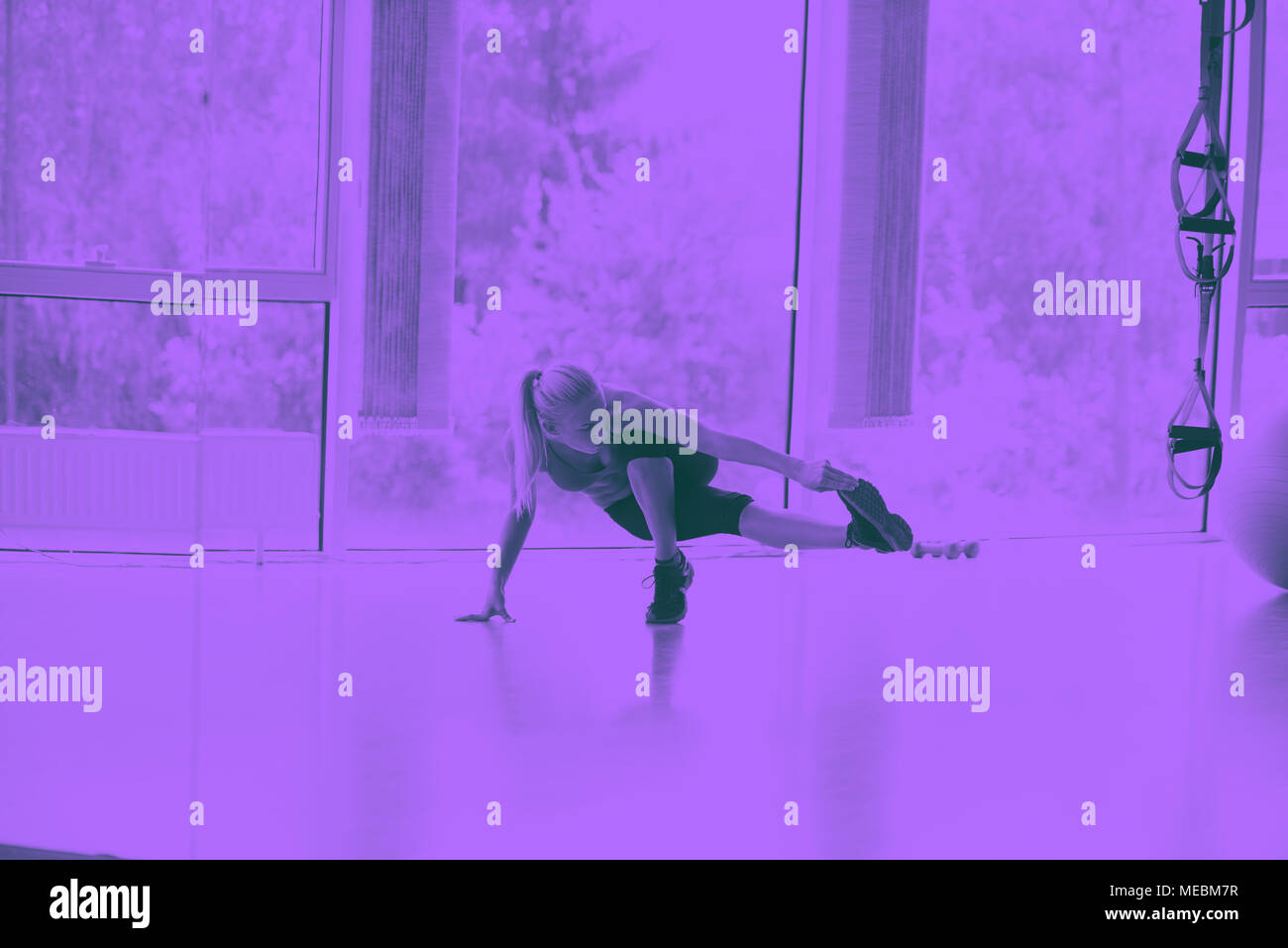 Cute young woman stretching and warming up for her training at a gym ...