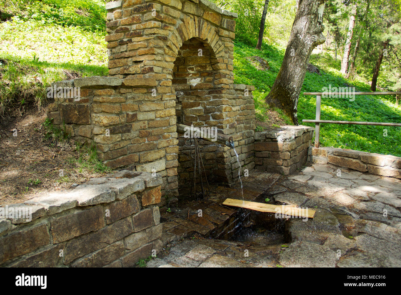 Water in a pipe from a spring in a wall of stone Stock Photo - Alamy