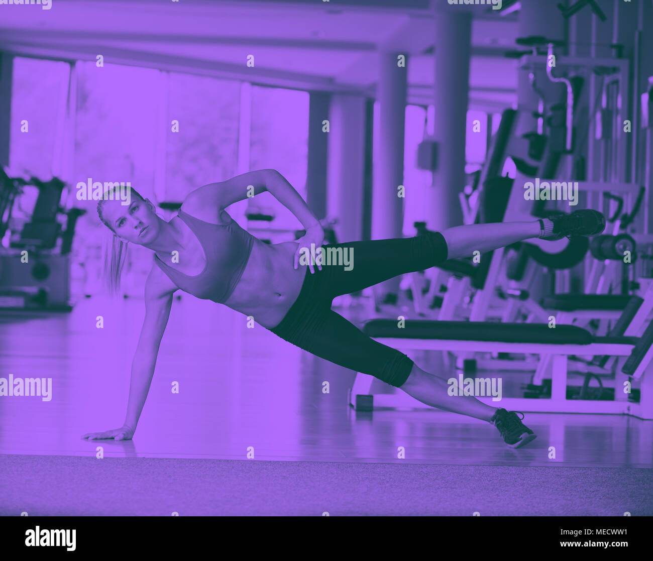 Cute young woman stretching and warming up for her training at a gym ...