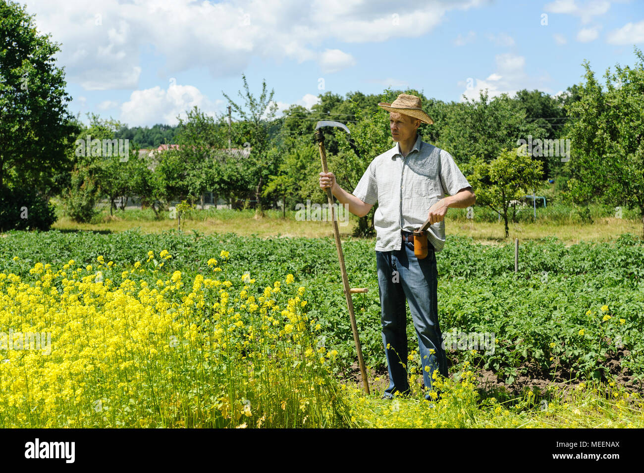A man is holding a spit in one hand and a sharpening stone in another ...