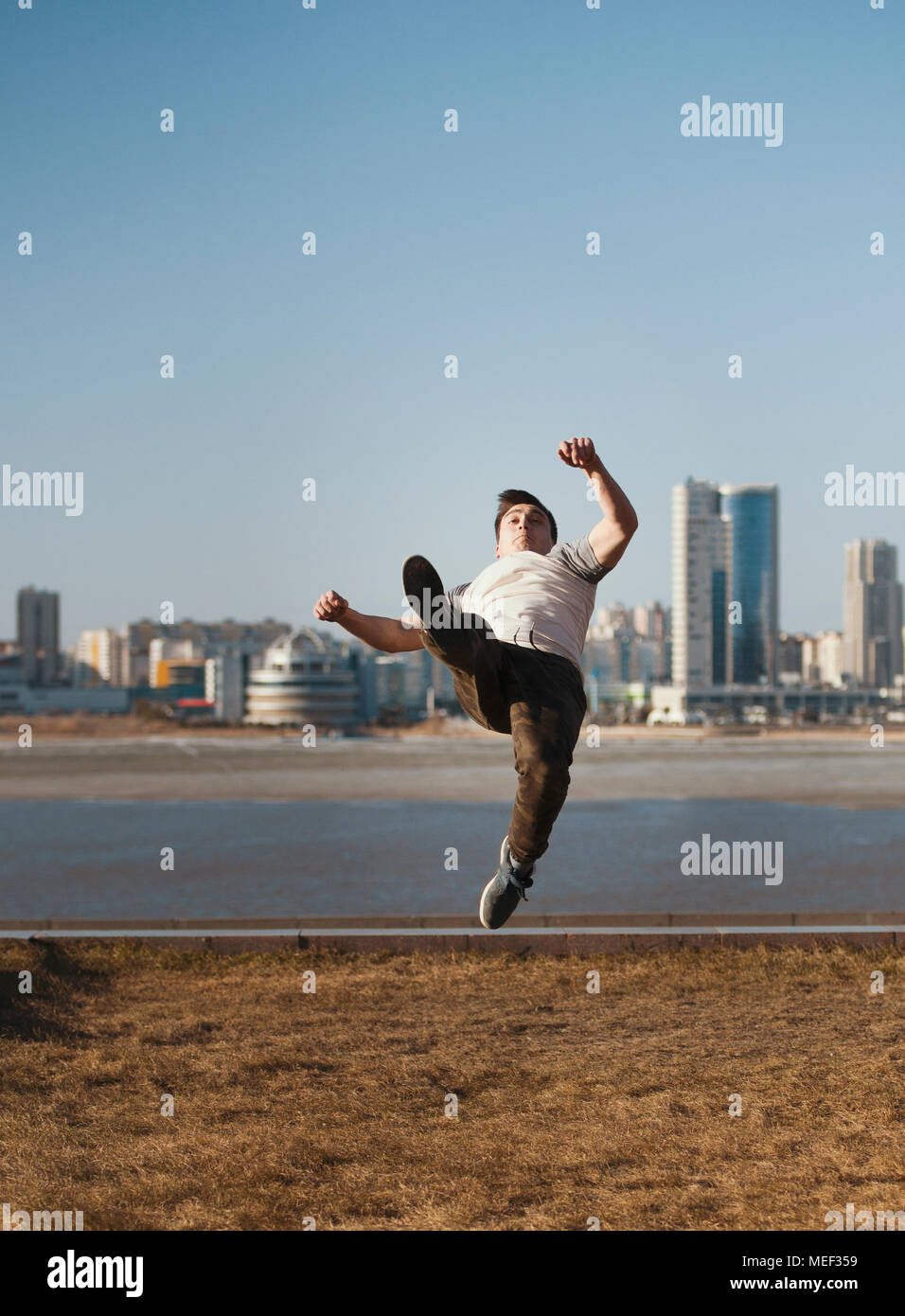 Young male parkour sportsman performs acrobatic jumps in front of ...