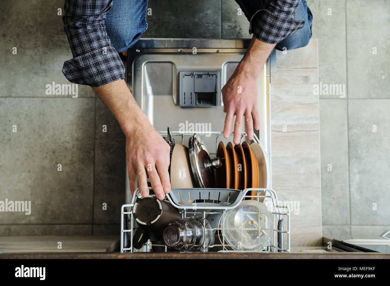 The man pushed the dirty dishes in the dishwashing machine Stock Photo ...
