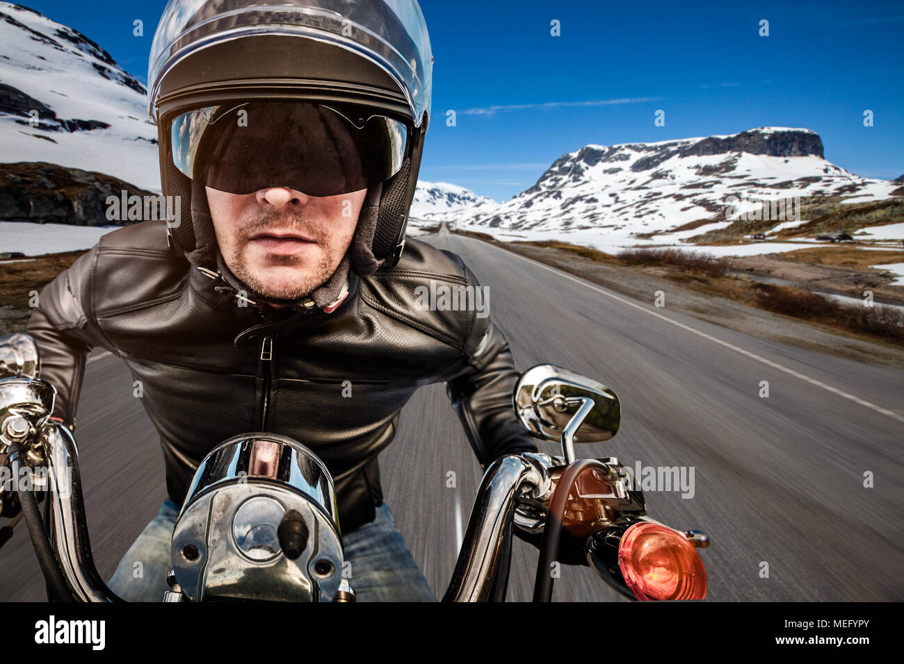 Biker driving a motorcycle rides along the asphalt road. First-person ...