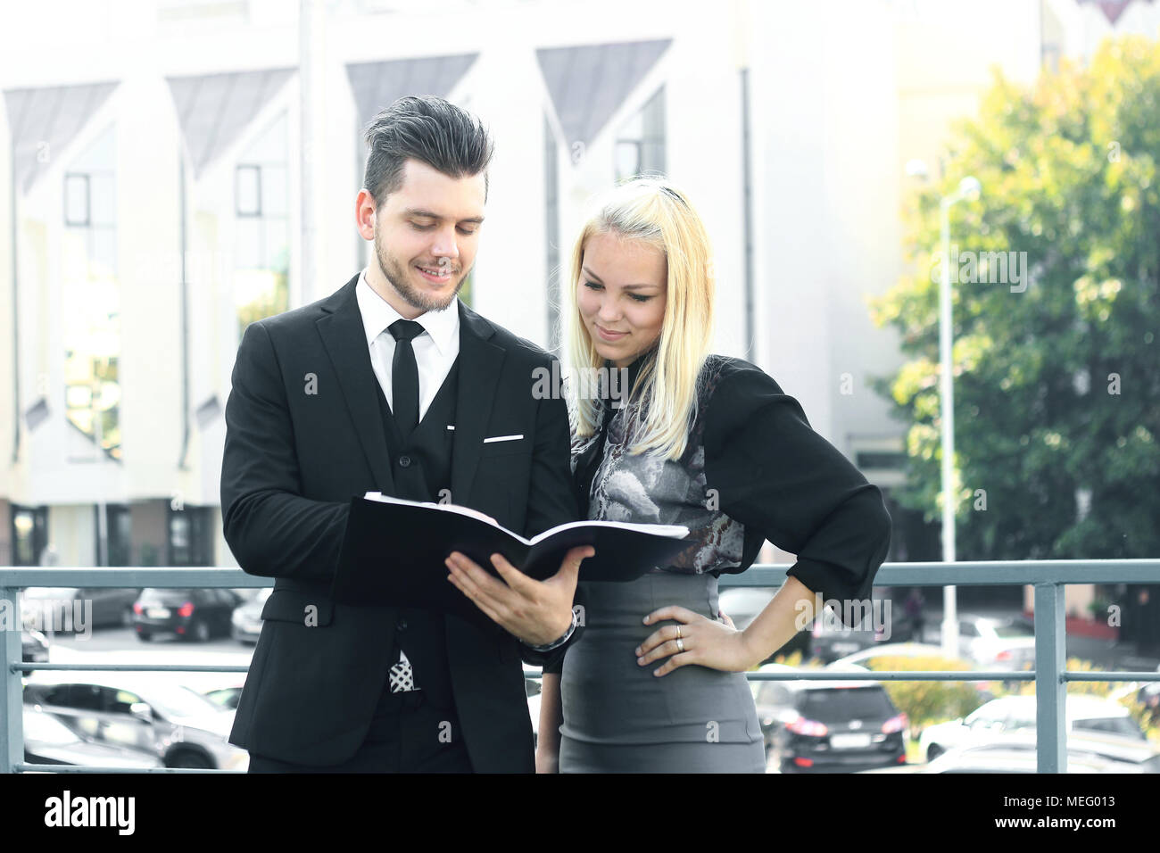 couple of employees reading documents standing near the office Stock ...