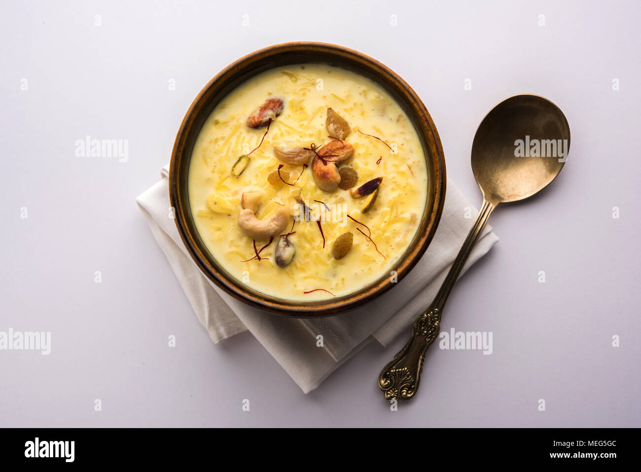 kheer or rice pudding is an Indian dessert in a brown terracotta bowl ...
