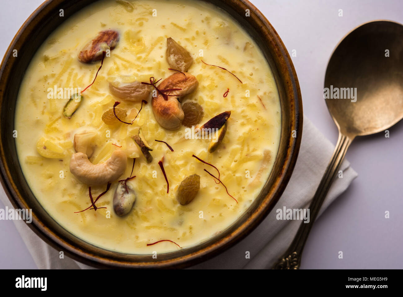 kheer or rice pudding is an Indian dessert in a brown terracotta bowl ...
