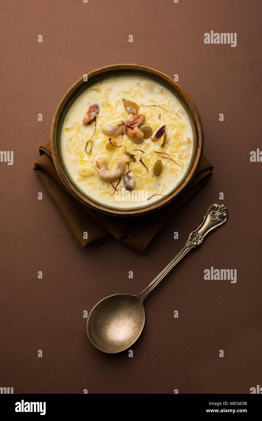 kheer or rice pudding is an Indian dessert in a brown terracotta bowl ...