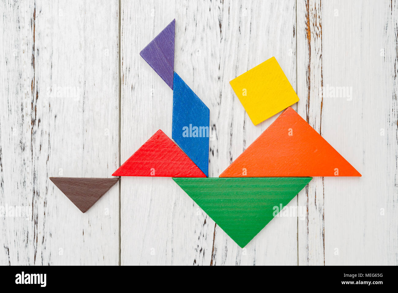 wooden tangram shaped like a people having a bicycle kick Stock Photo ...