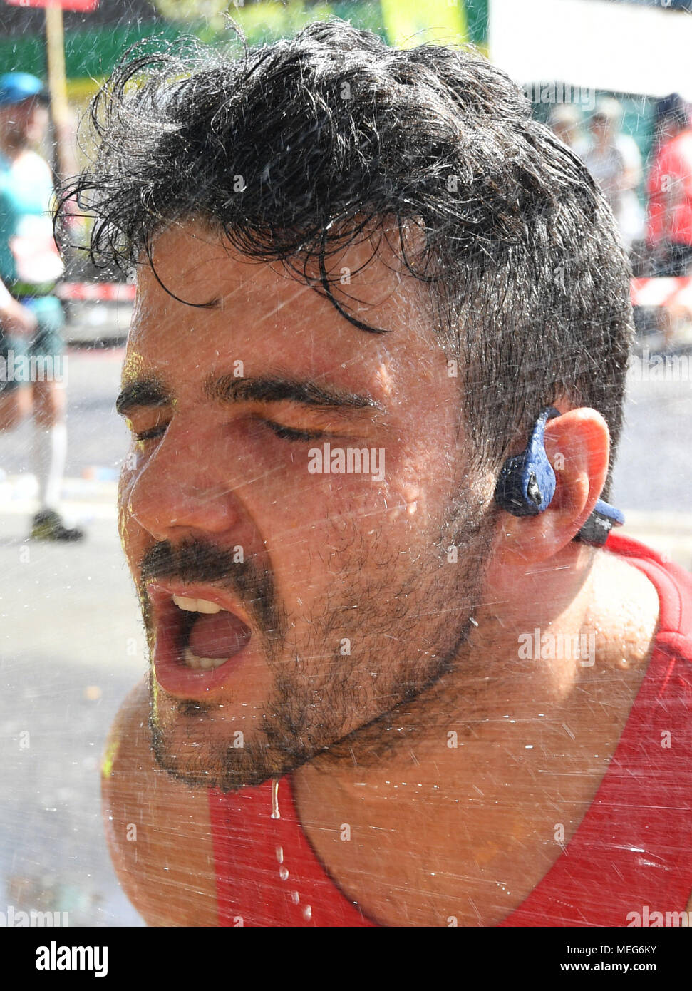 A runner uses a shower to cool off during the 2018 Virgin Money London ...