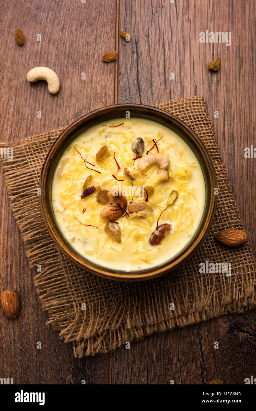 kheer or rice pudding is an Indian dessert in a brown terracotta bowl ...
