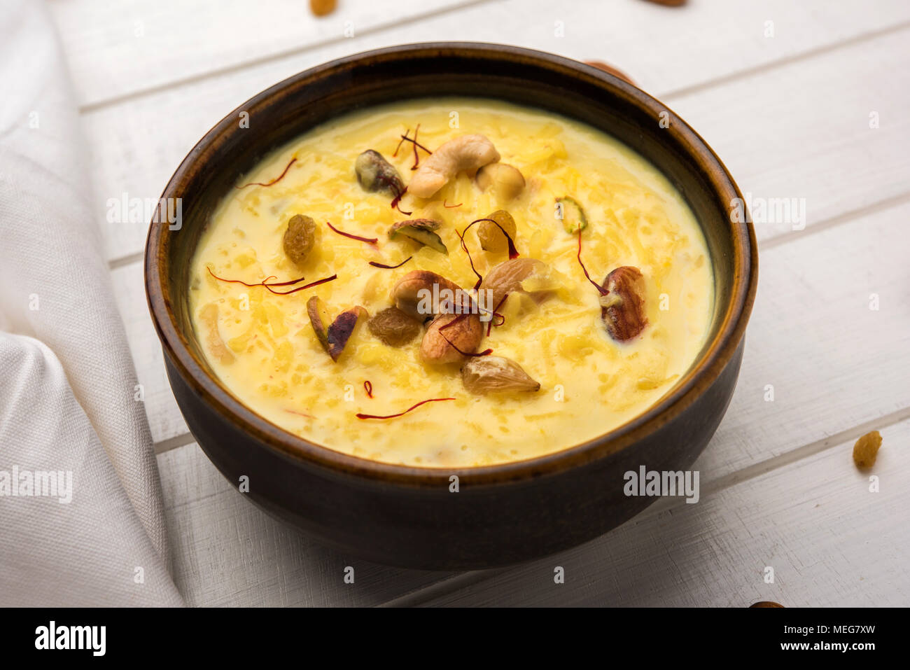 kheer or rice pudding is an Indian dessert in a brown terracotta bowl ...