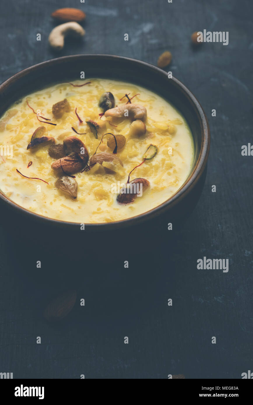 kheer or rice pudding is an Indian dessert in a brown terracotta bowl ...