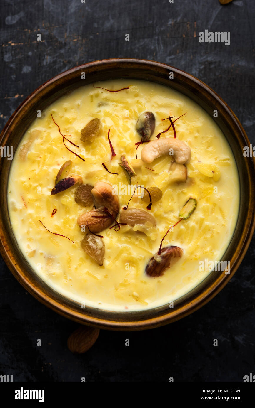 kheer or rice pudding is an Indian dessert in a brown terracotta bowl ...