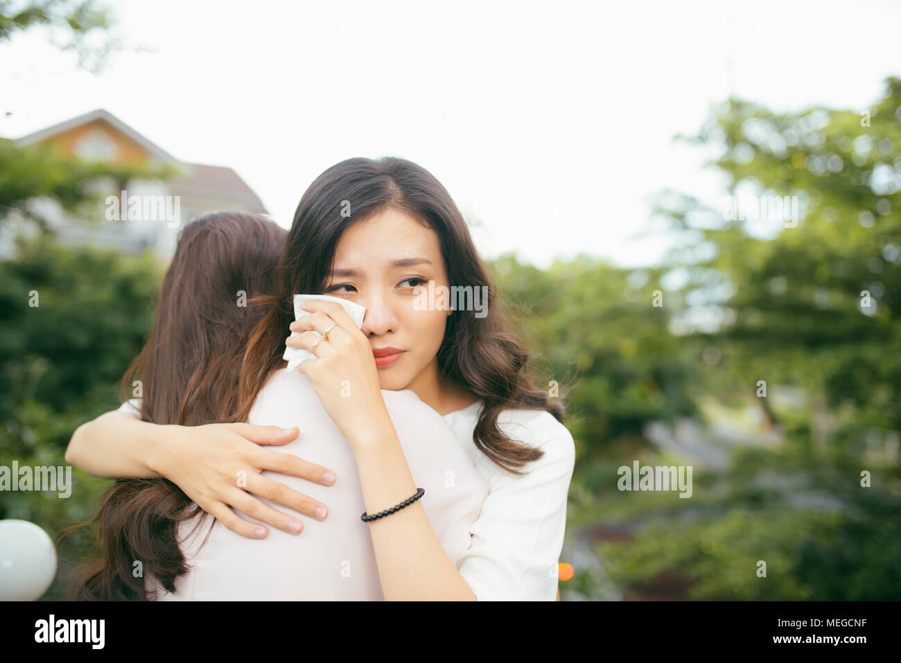 Friendship help support. Depressed asian woman embracing her friend ...