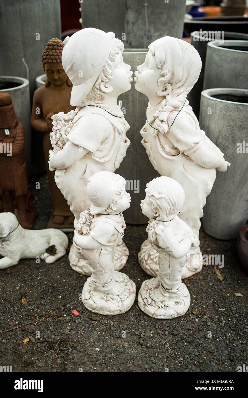 Small white stone statue of two children kissing Stock Photo - Alamy