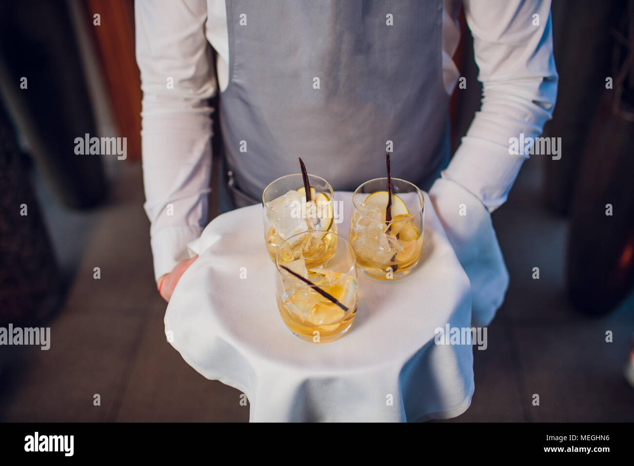 Man in suit holding silver tray with glasses of whiskey waiter garcon ...