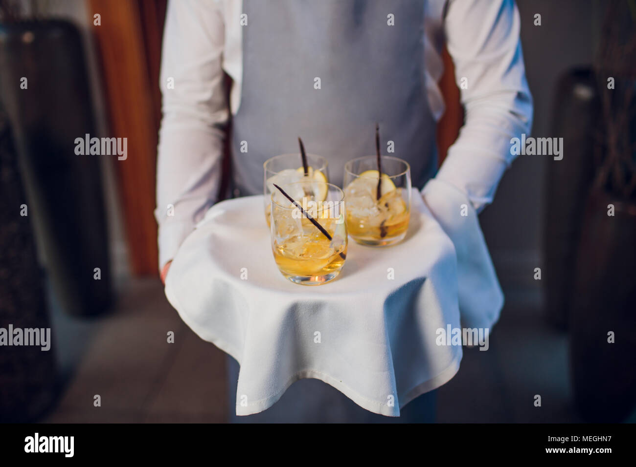 Man in suit holding silver tray with glasses of whiskey waiter garcon ...