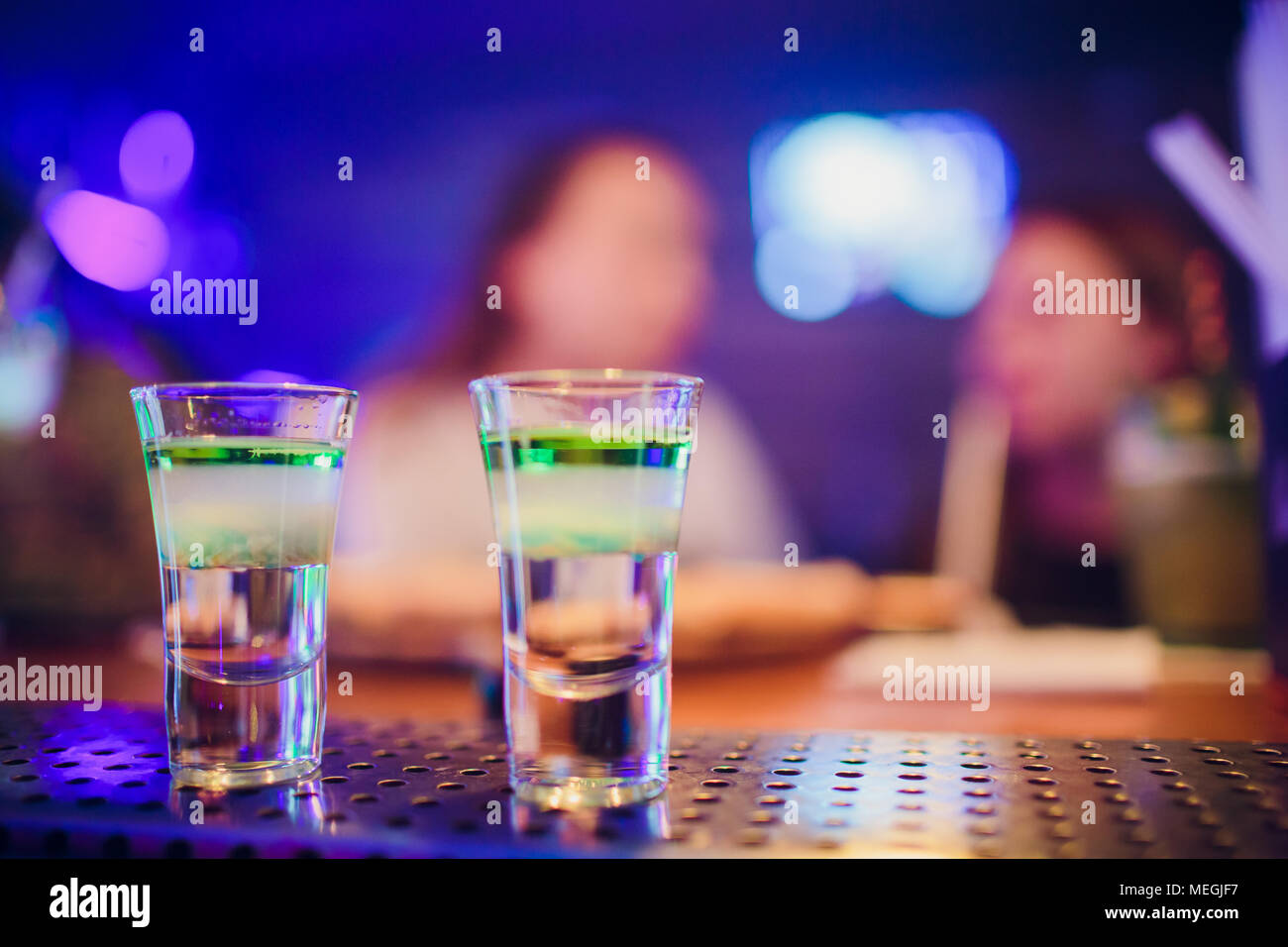 Multicolored shots on bar against the background of the bar's visitors ...