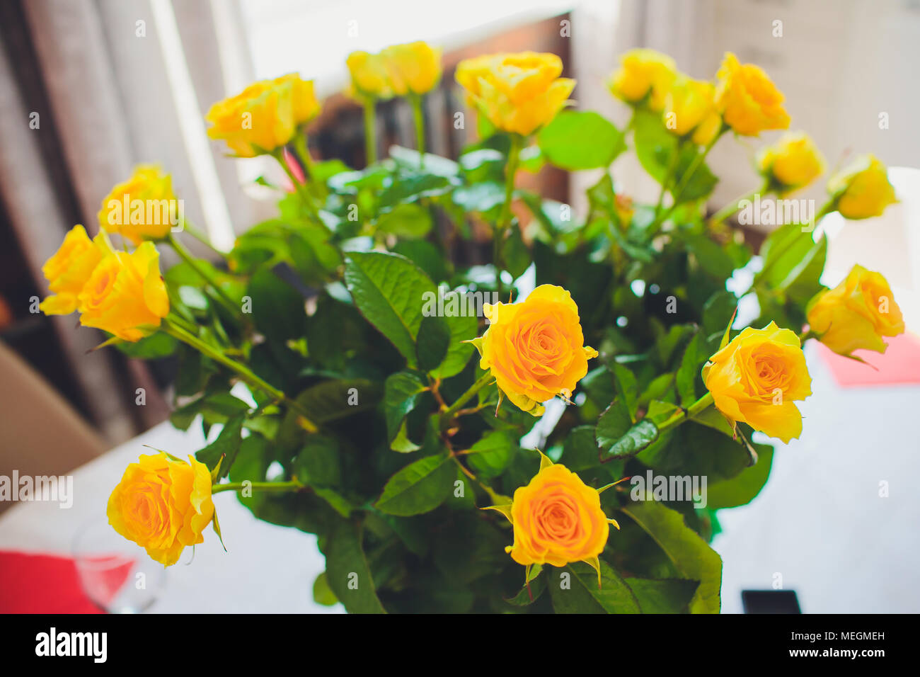 Yellow roses in vase on the table Stock Photo - Alamy