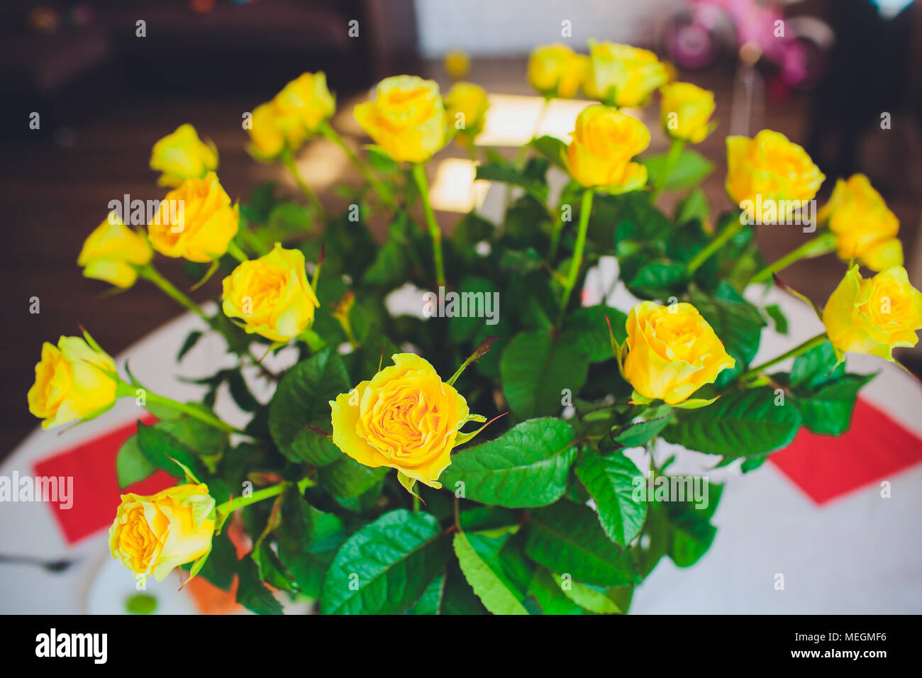 Yellow roses in vase on the table Stock Photo - Alamy