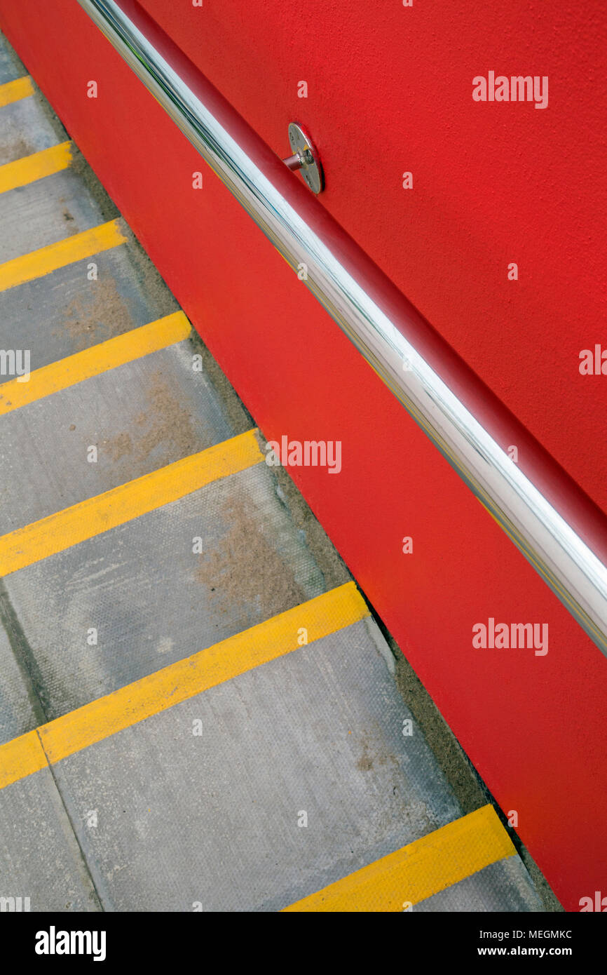 Abstract portrait format image of steps with a strong red colour and ...