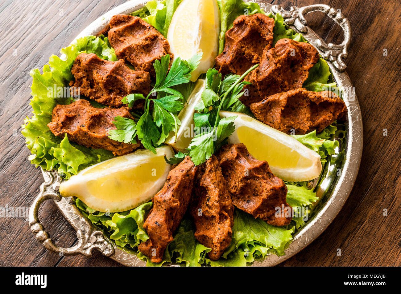 Turkish Food Cig Kofte with lemon, lettuce and parsley on silver tray ...
