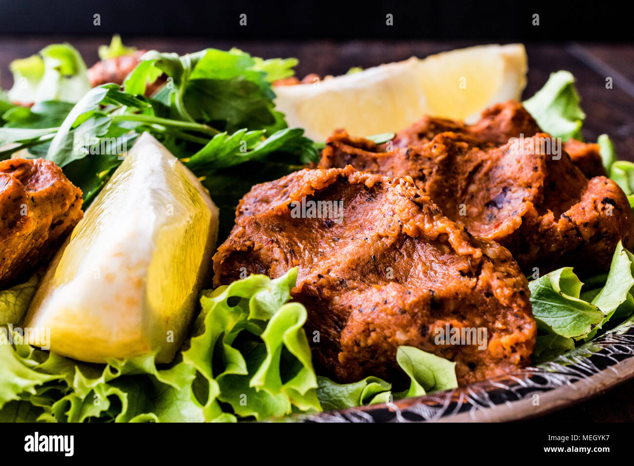Turkish Food Cig Kofte with lemon, lettuce and parsley on silver tray ...