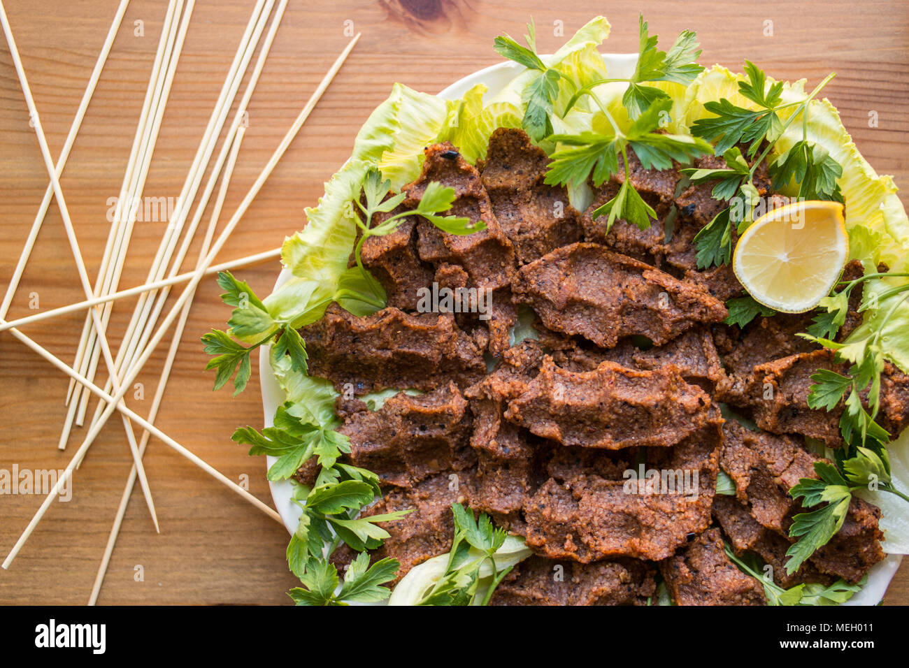 Turkish Food Cig Kofte with lemon, lettuce and parsley on silver tray ...