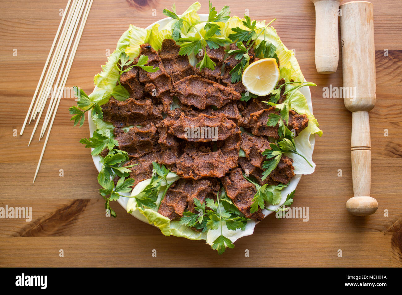 Turkish Food Cig Kofte with lemon, lettuce and parsley on silver tray ...