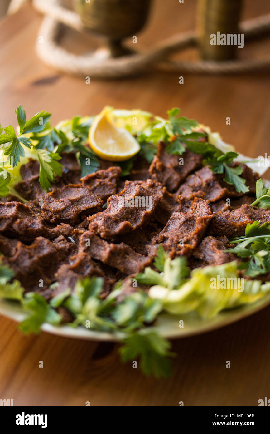 Turkish Food Cig Kofte with lemon, lettuce and parsley on silver tray ...